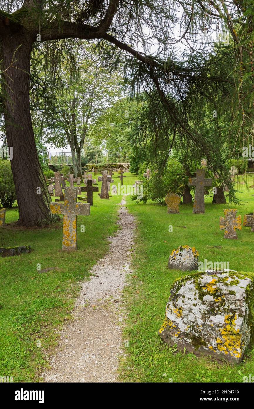 Gravel path through cemetery with old grave markers and crosses covered ...