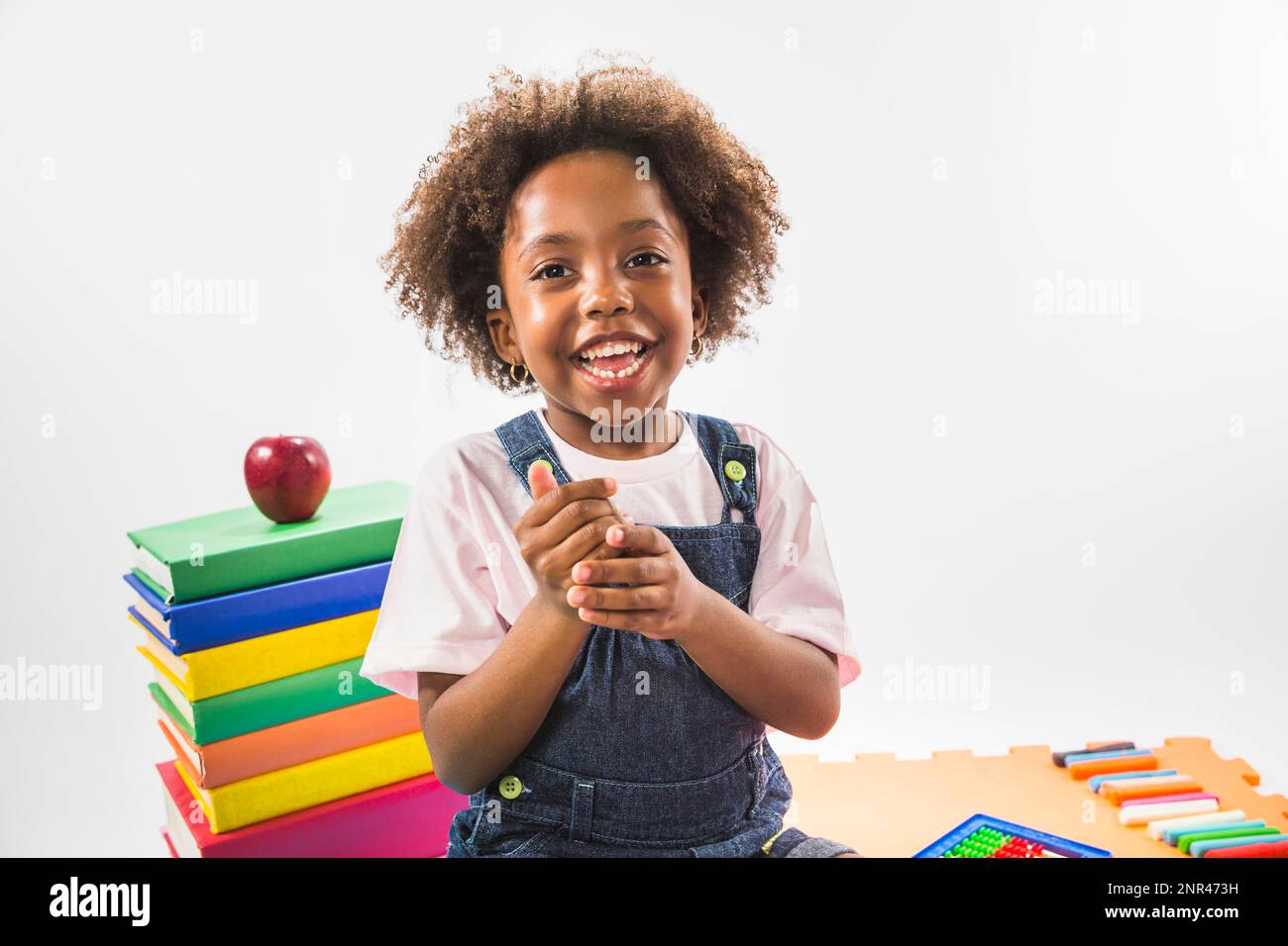 kid sitting books smiling studio. High resolution photo Stock Photo - Alamy