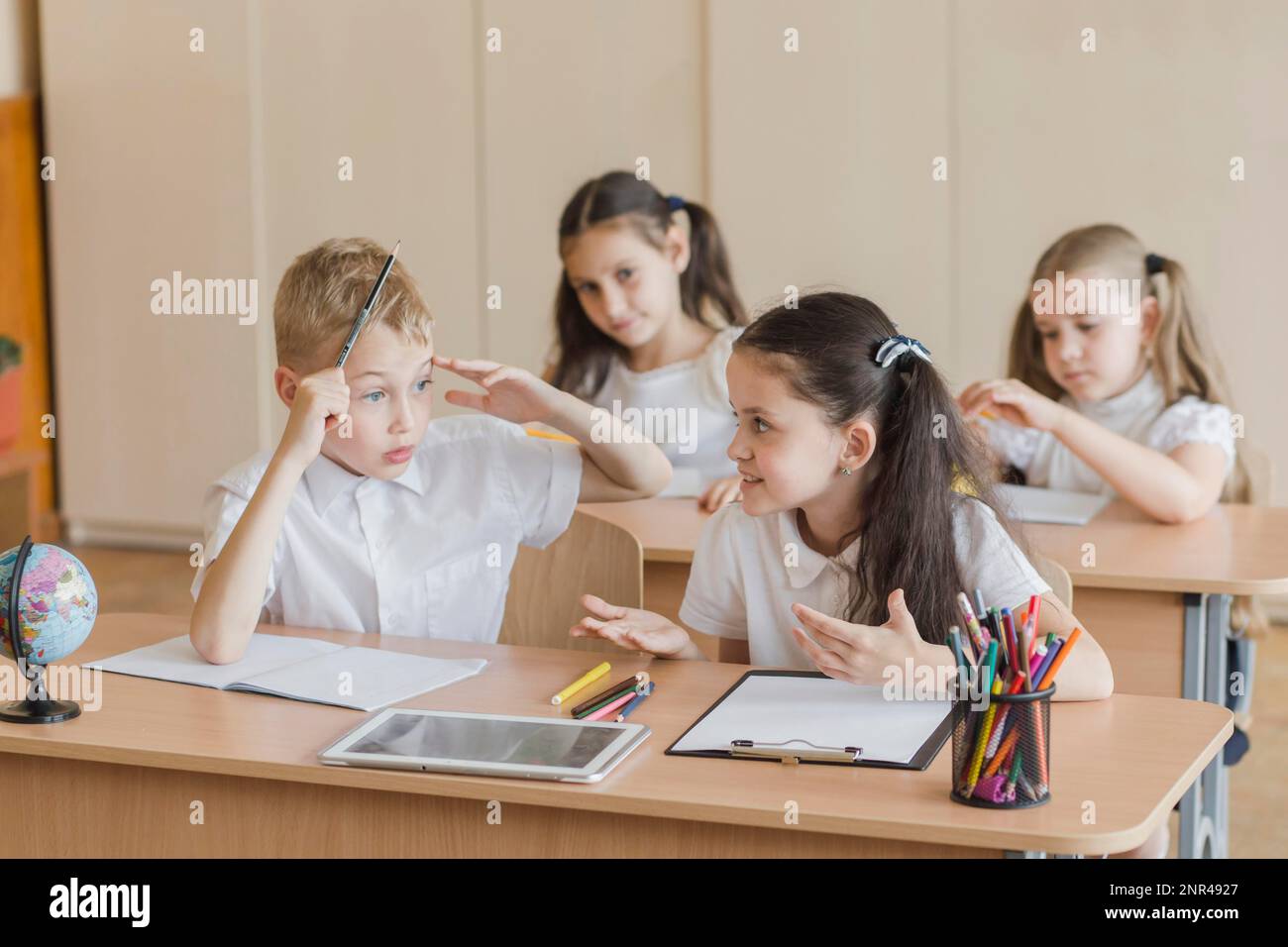 Girl talking with boy during lesson Stock Photo - Alamy
