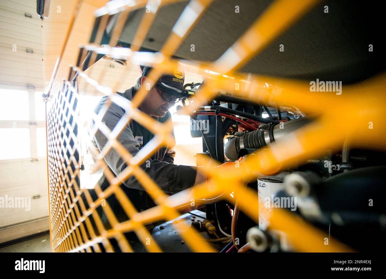 Bus technician Michael Johanson inspects components on a school bus ...