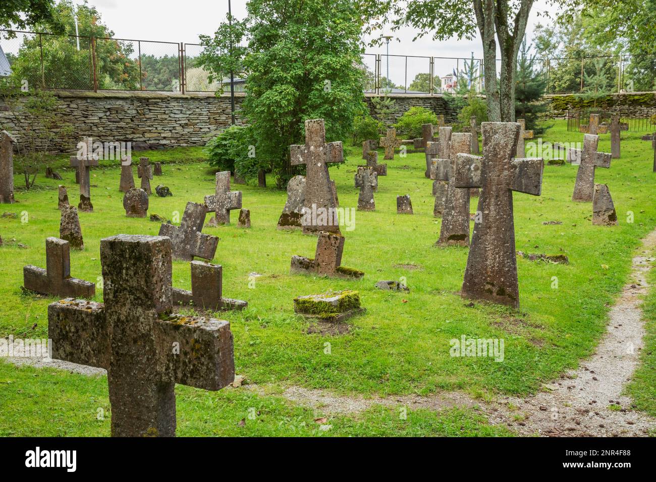 Old moss and lichen growth covered stone crosses on top of graves in ...