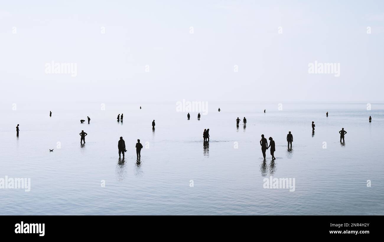 large group of people or crowd standing walking and swimming in shallow ...