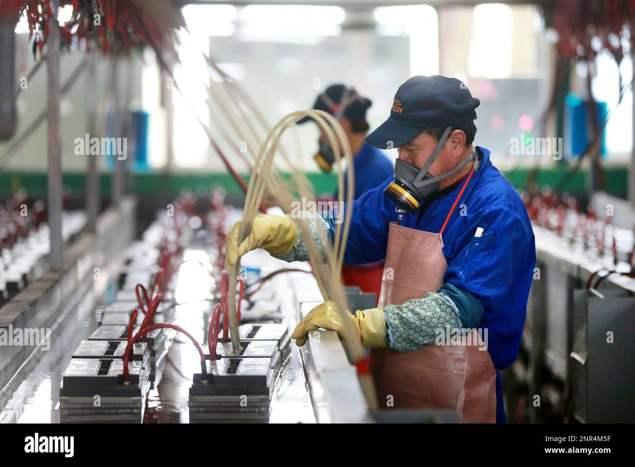Masked workers labor in a factory of lead-acid batteries in Suixi ...