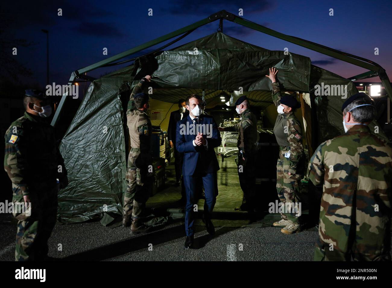 French President Emmanuel Macron wears a face mask during his visit at ...