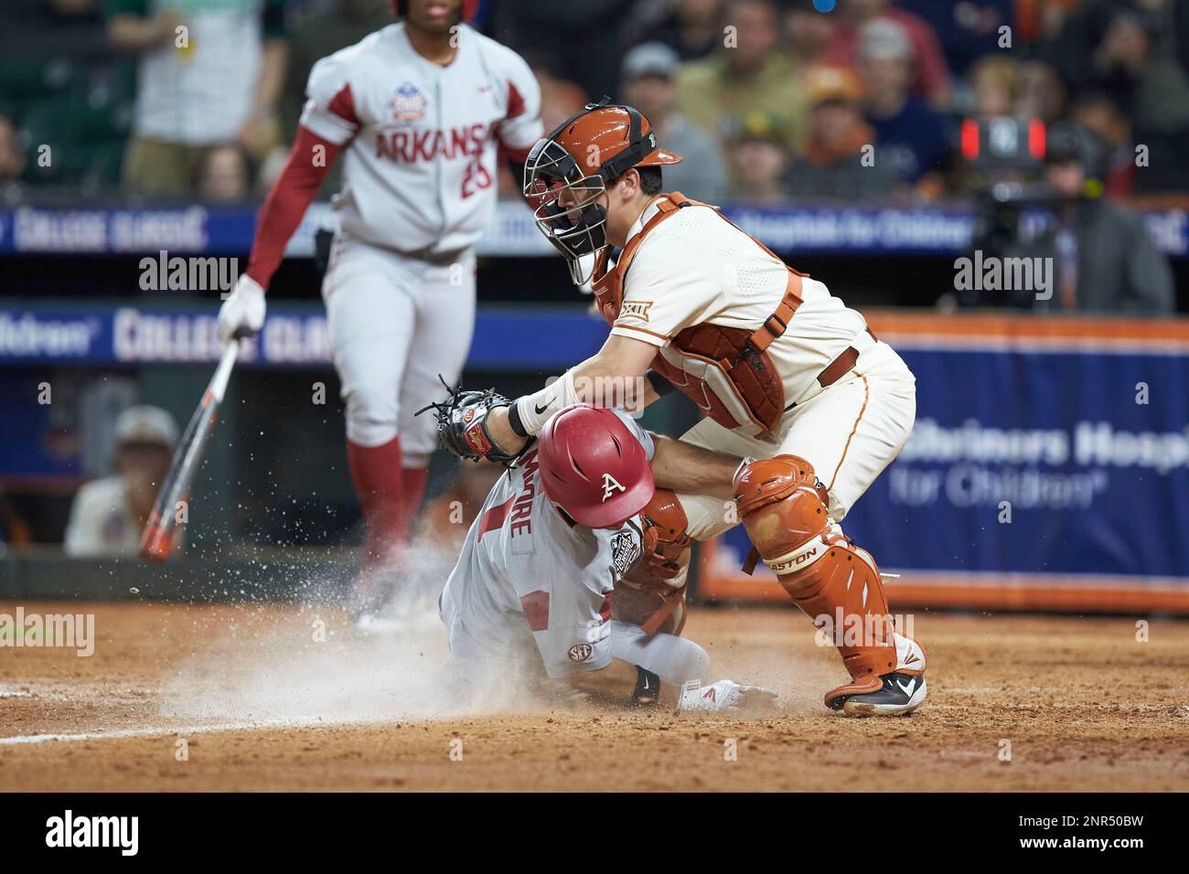 Robert Moore (1) of the Arkansas Razorbacks slides into home plate ...