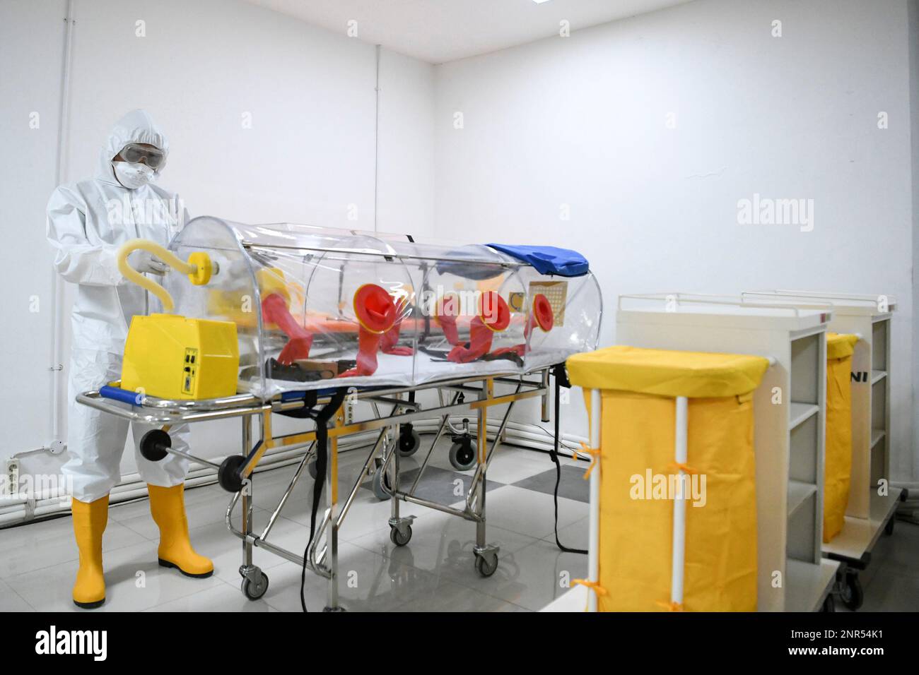 A staff member inspects an isolation chamber at an emergency hospital ...