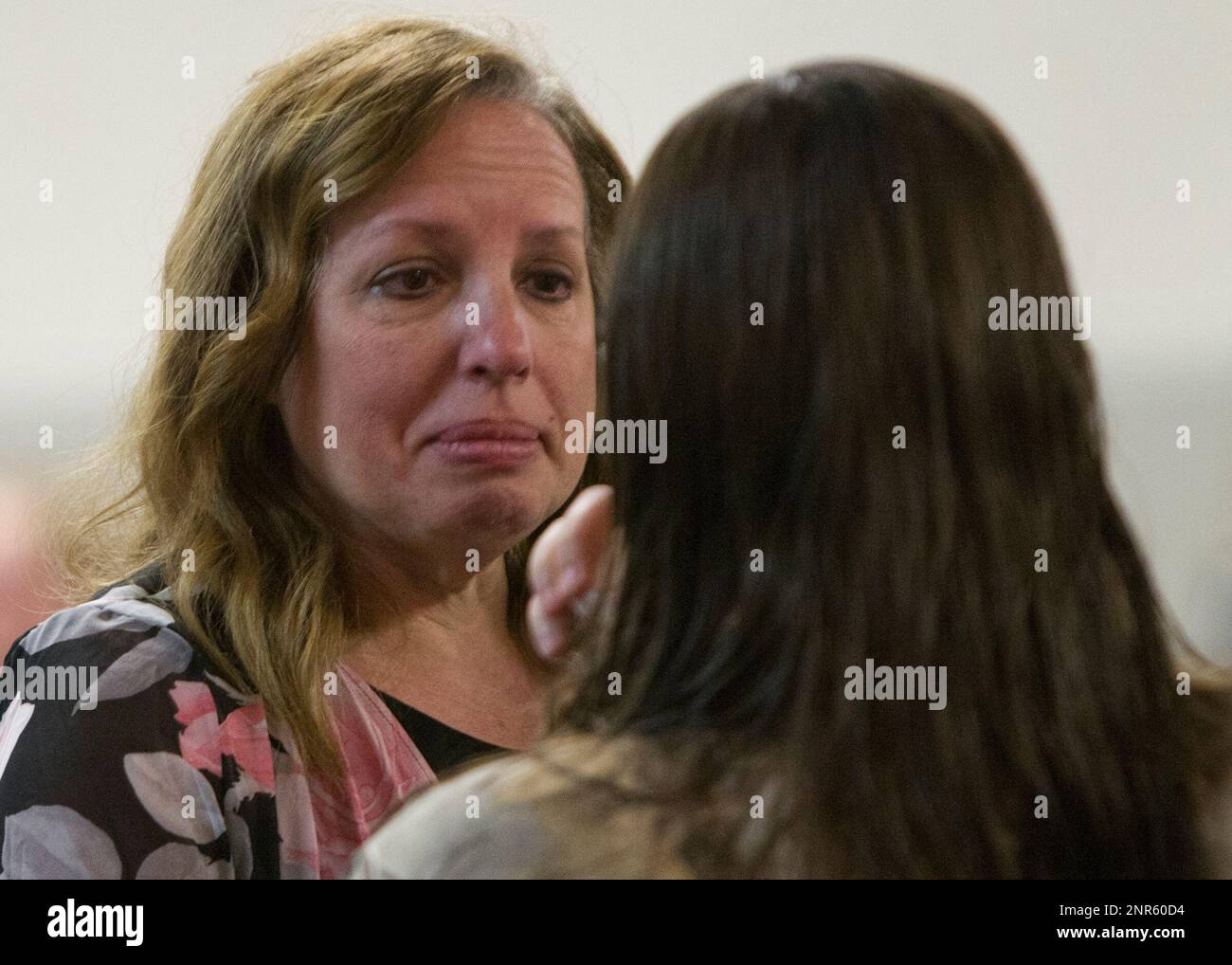 Kim Phillips is consoled by an attendee of a memorial service for her ...