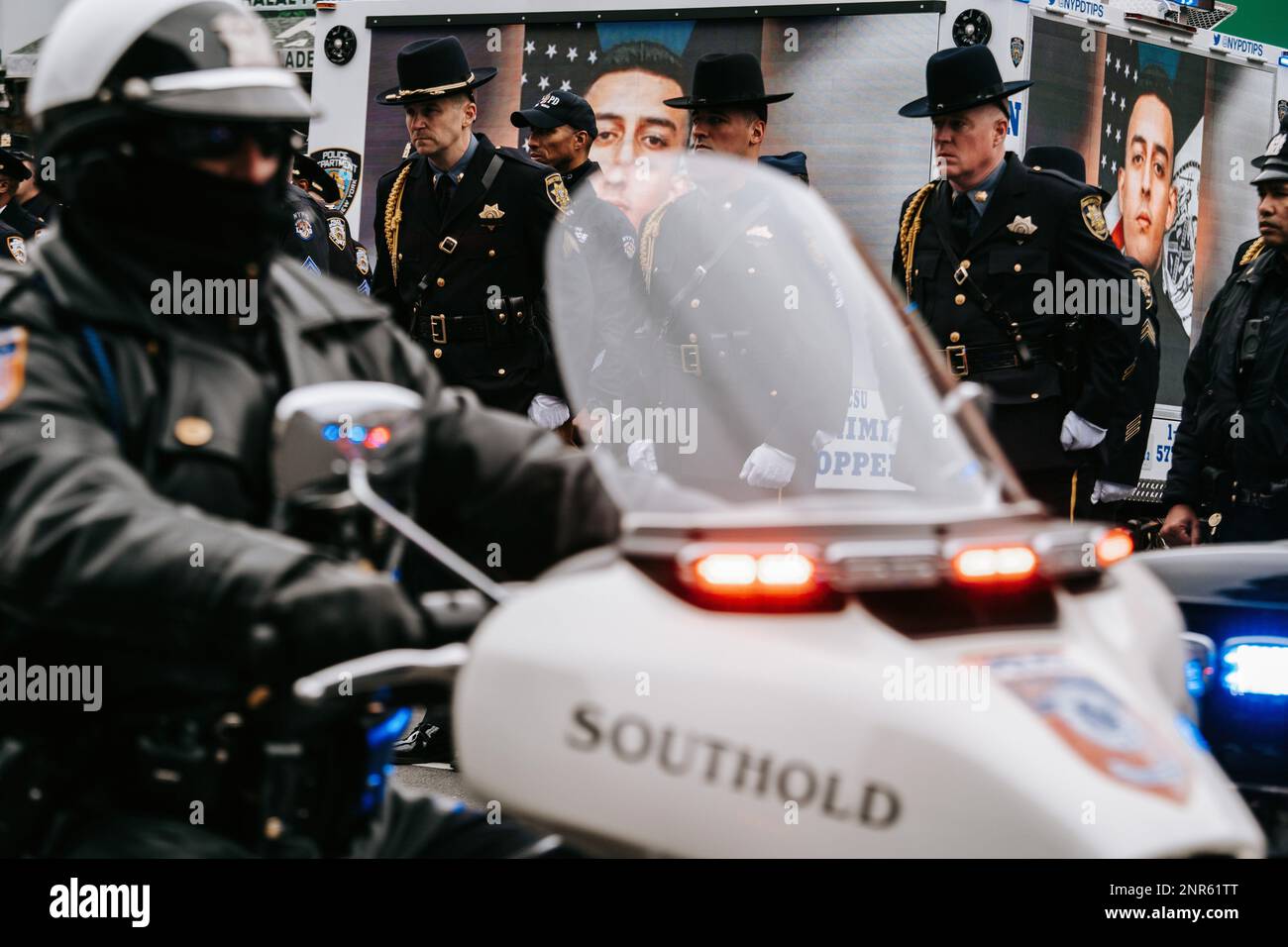 NY State police officers stand at attention in front of a portrait of ...