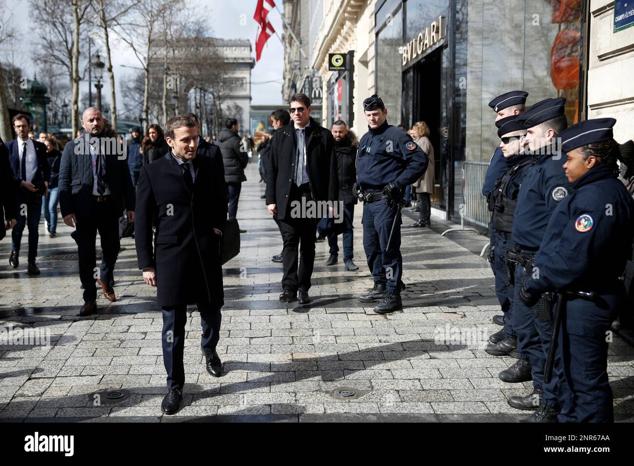 French President Emmanuel Macron walks down the Champs-Elysees avenue ...