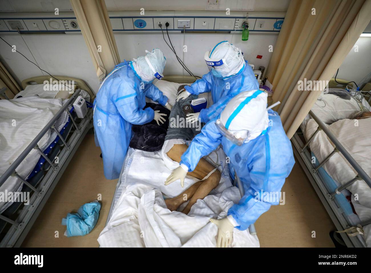 Nurses change diaper for a senile patient in a hospital designated for ...