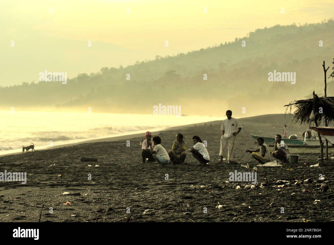 People are having a group conversation on a sandy beach in Batuputih ...