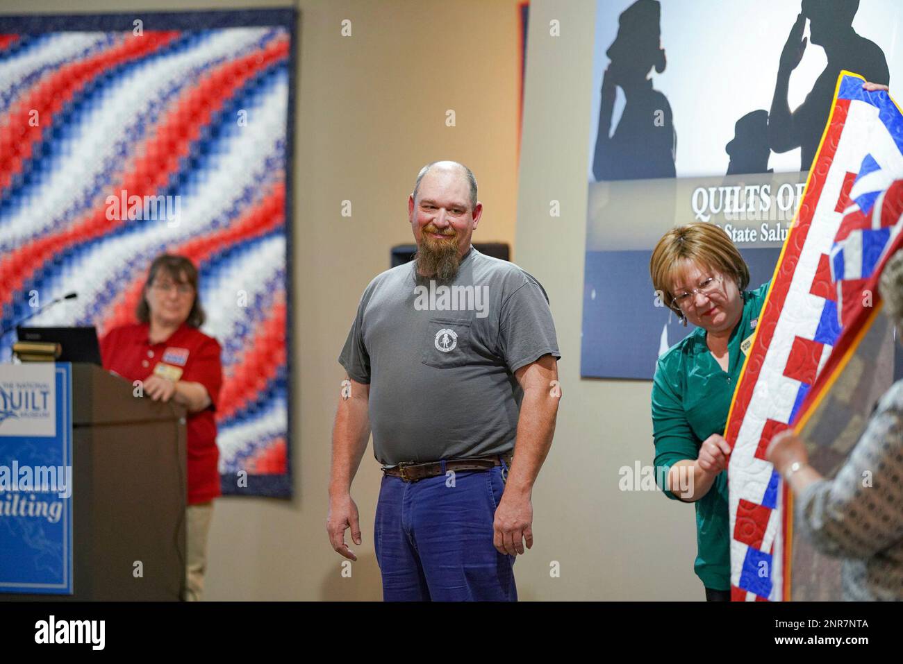 David Wayne Downing Jr looks proudly at a quilt being presented to him ...