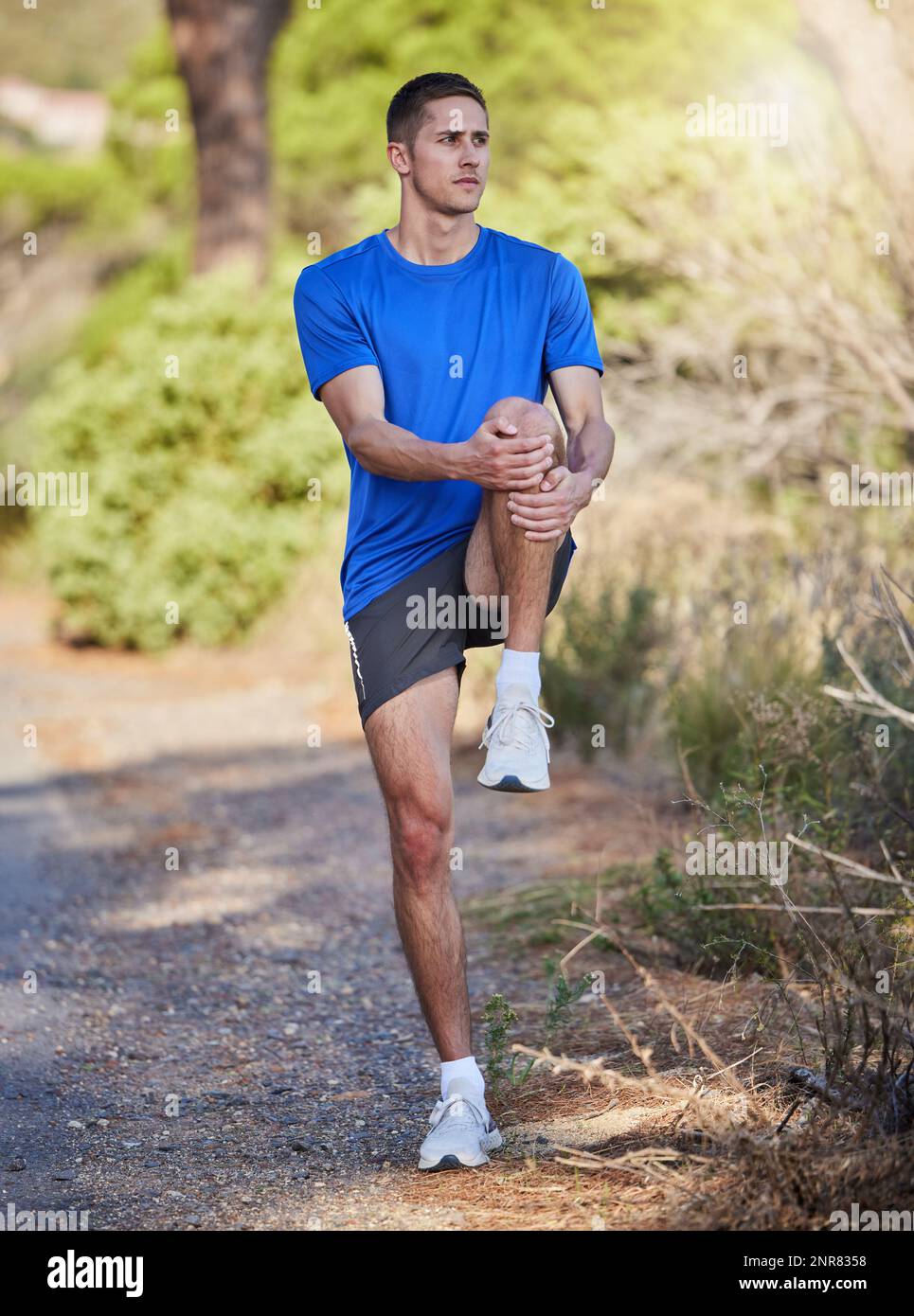 Fitness, stretching legs and man in nature getting ready for running ...