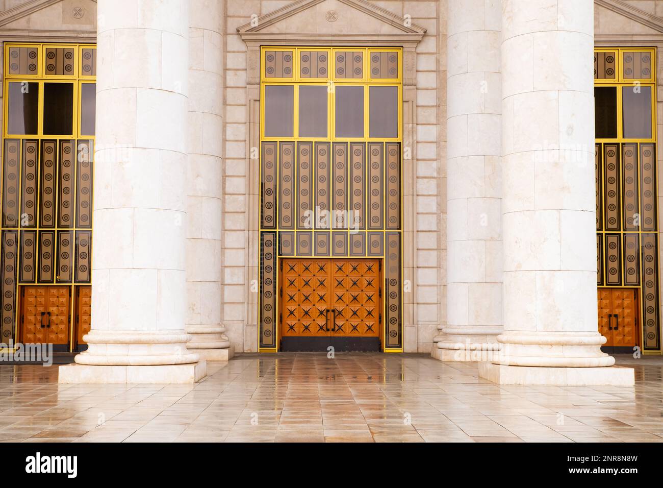 Yellow orange large wooden doors decorated with metal stars and columns ...