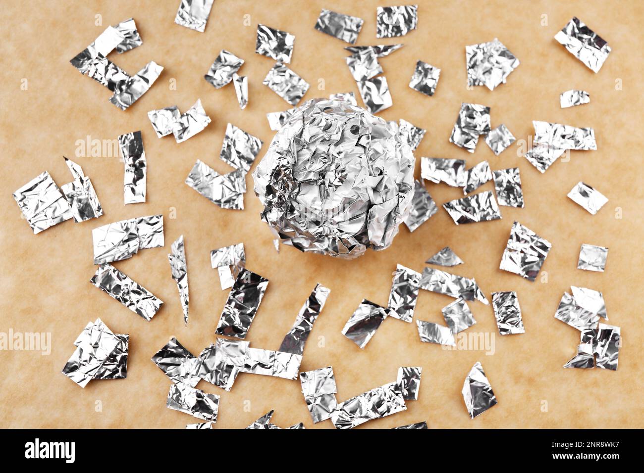 Crumpled ball and pieces of aluminium foil on color background Stock ...