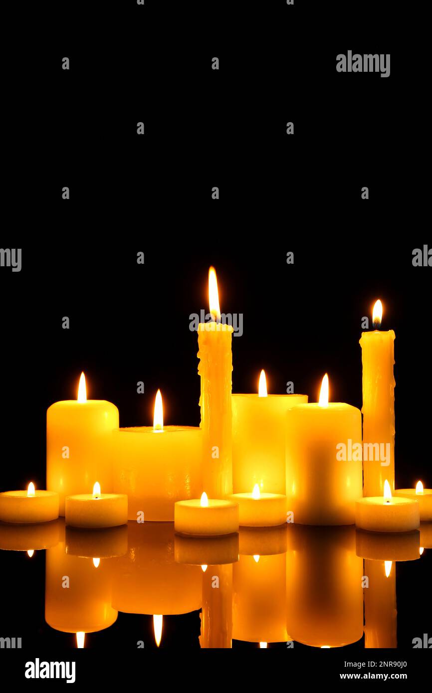 Burning candles on dark background. Mourning concept Stock Photo - Alamy