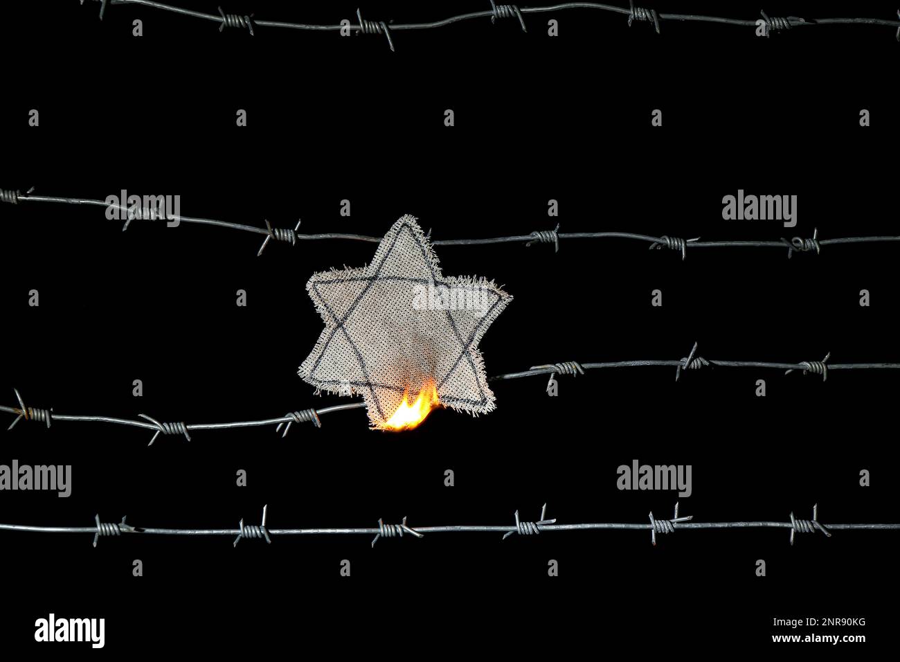 Barbed wire with burning Jewish badge on dark background. International ...
