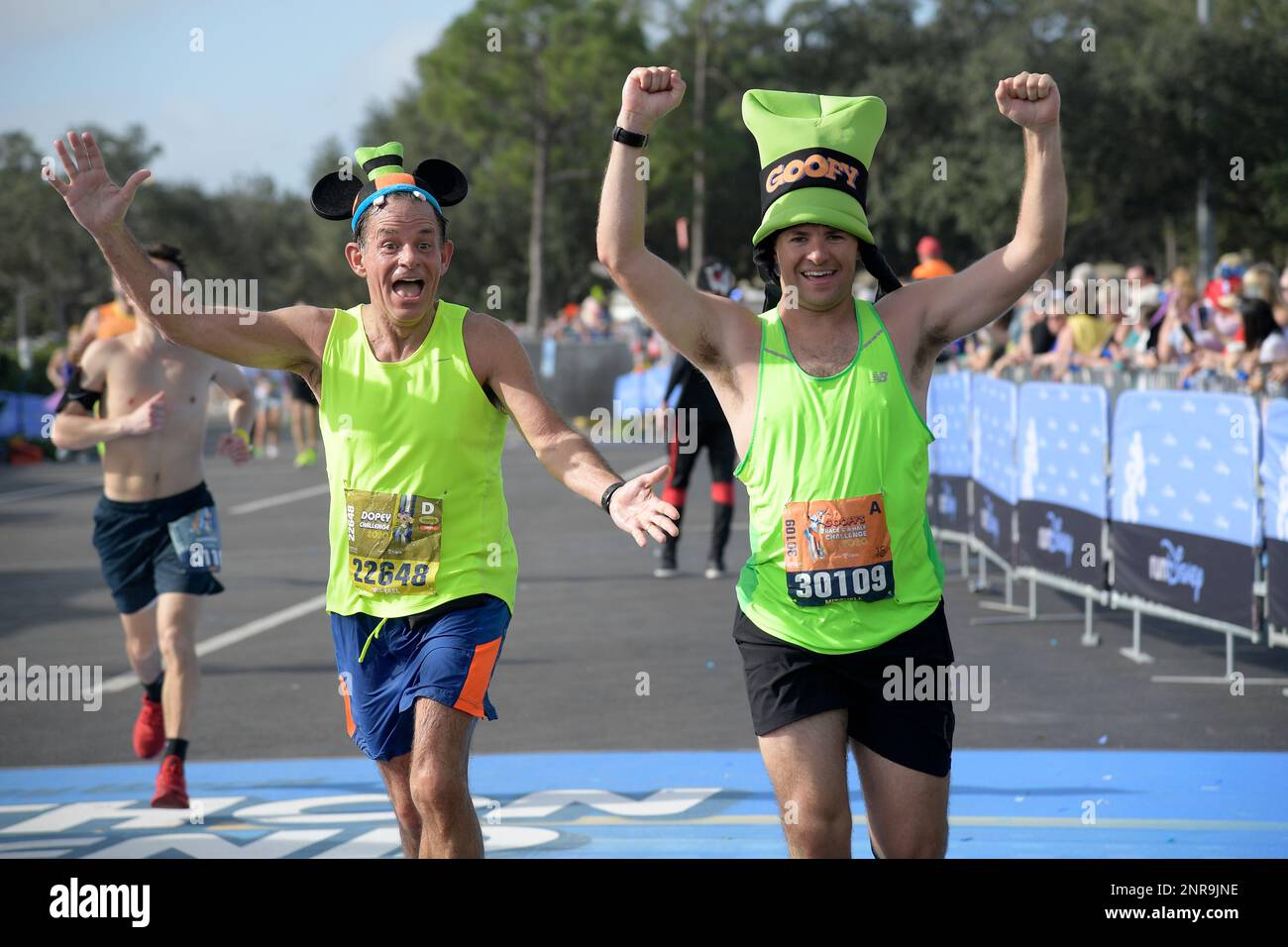 Runners cross the finish line during the Walt Disney World Marathon ...