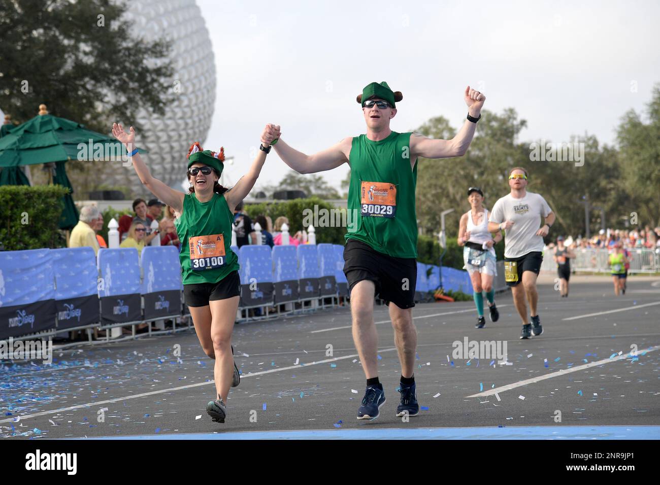 Runners celebrate while crossing the finish line during the Walt Disney ...