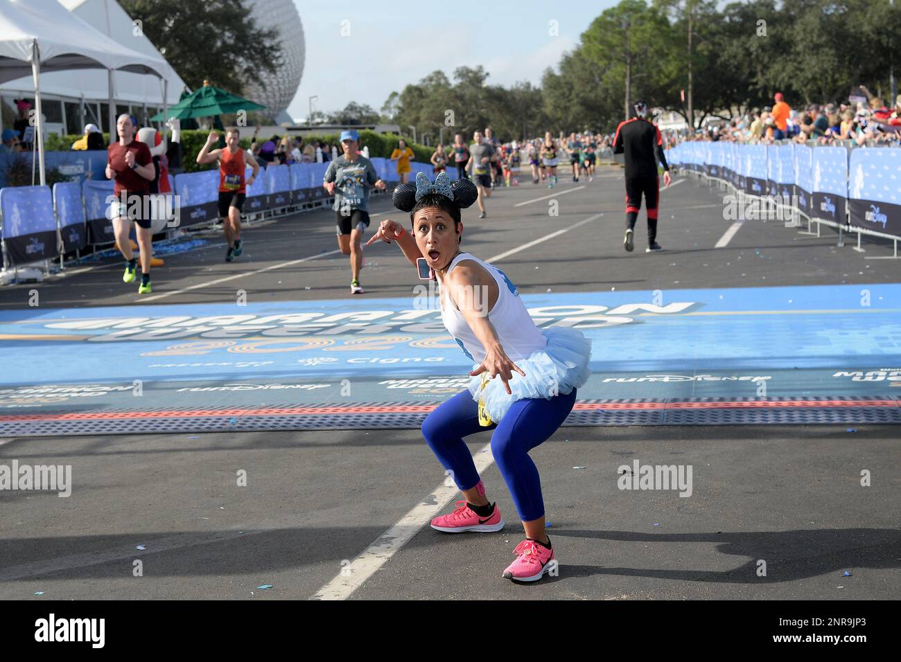 A runner celebrates after crossing the finish line during the Walt ...