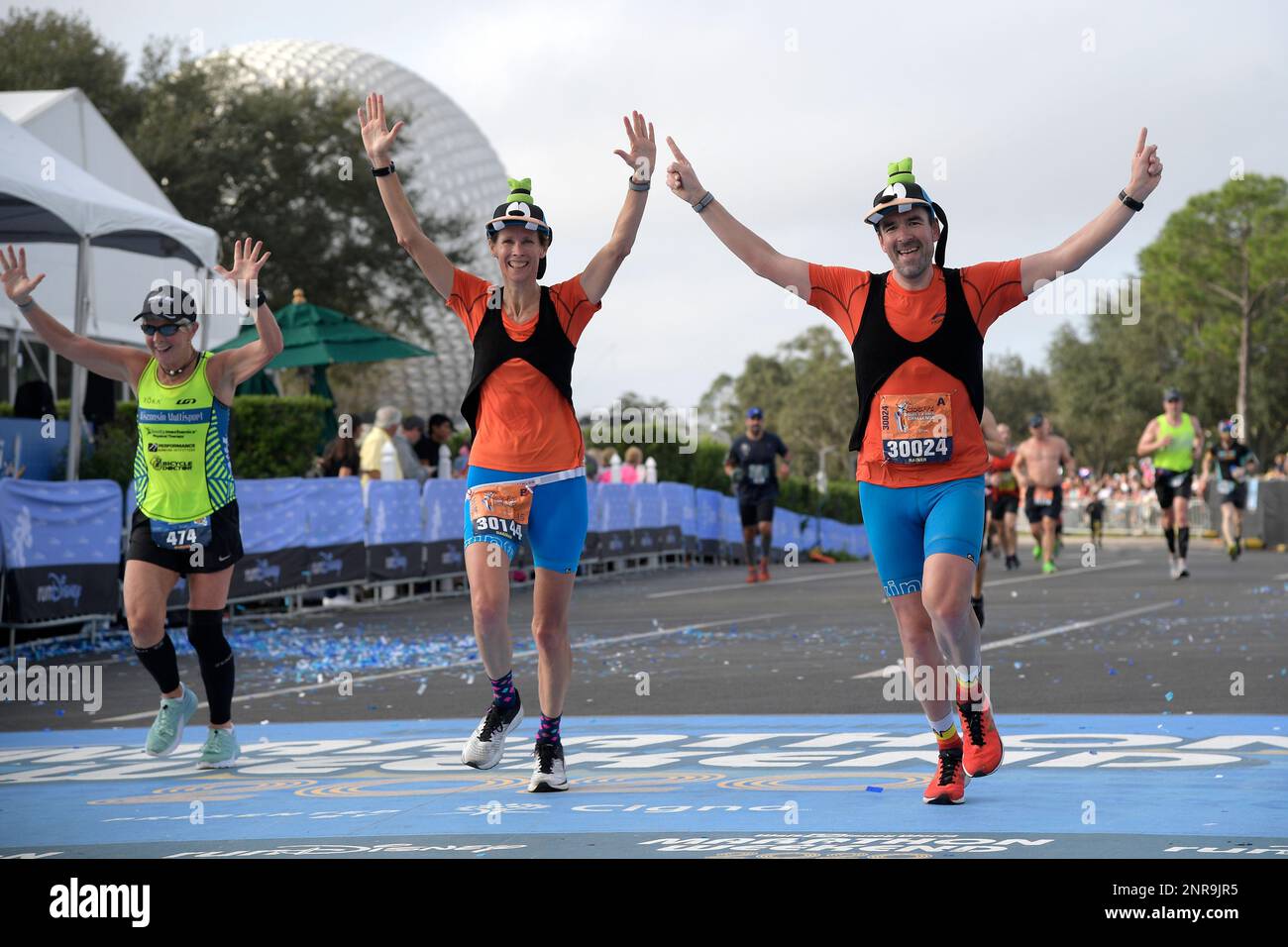 Runners celebrate while crossing the finish line during the Walt Disney ...