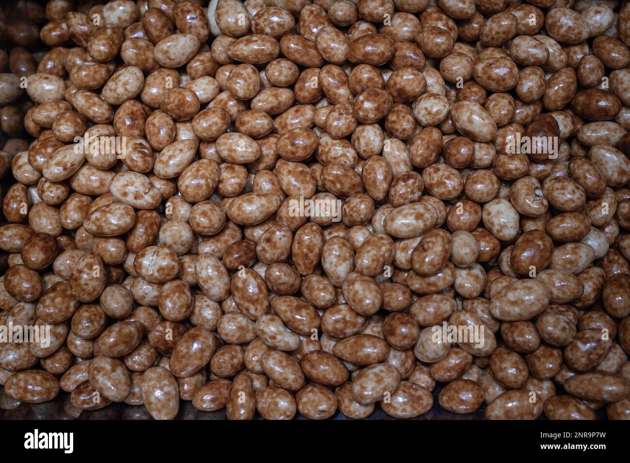 A bunch of hard candy looking like eggs or beans. Brown and white ...