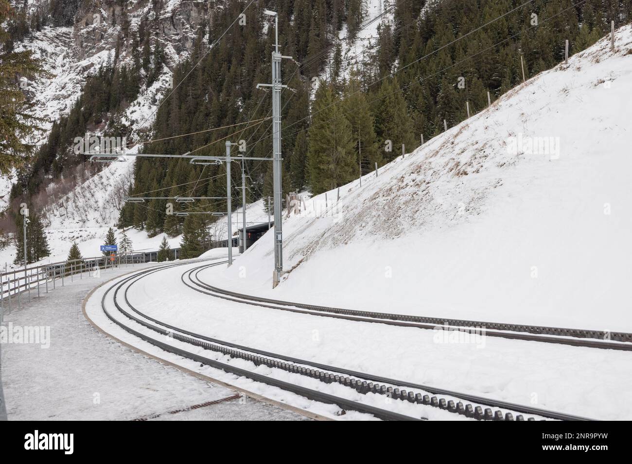 Narrow gauge cog railway above Wengen on a winter day with snow. Empty ...