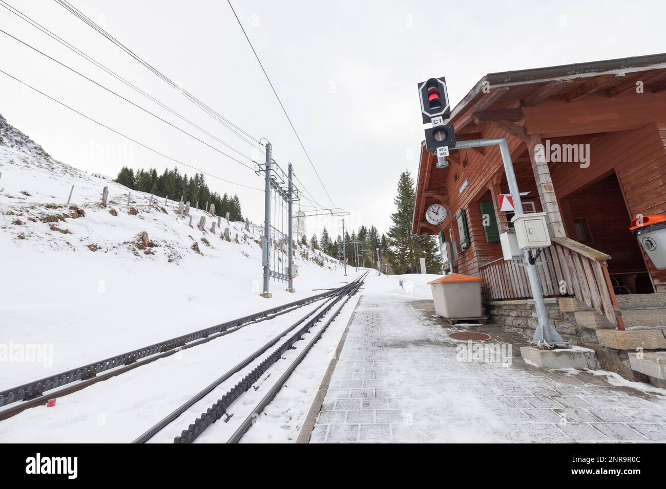 Narrow gauge cog railway above Wengen on a winter day with snow. Empty ...