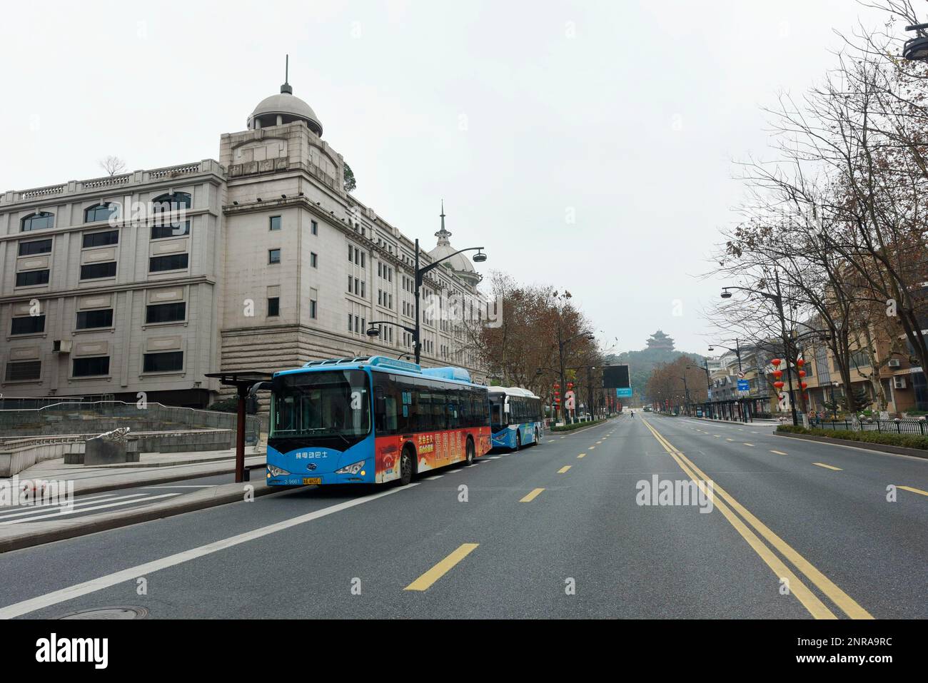 Buses stop at a bus stop on the nearly empty road in Hangzhou in east ...