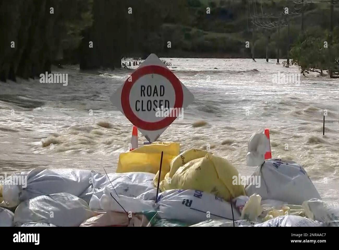 In this image made from video, sandbags are piled as a road is flooded ...