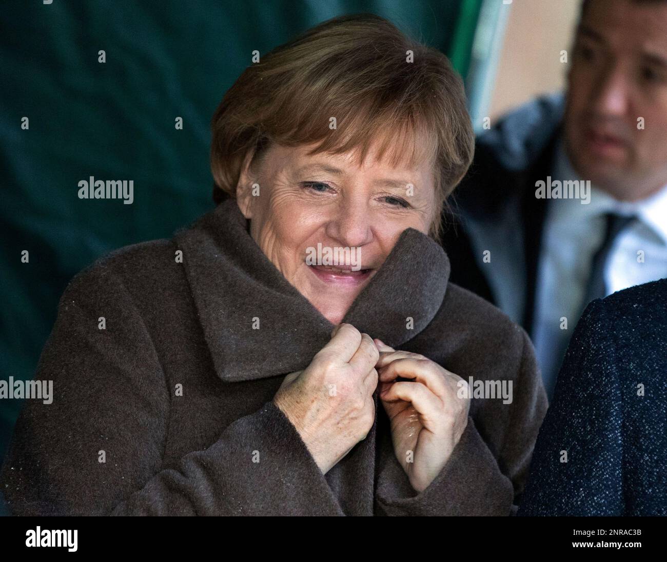 German Chancellor Angela Merkel adjusts her coat on a site of the ...