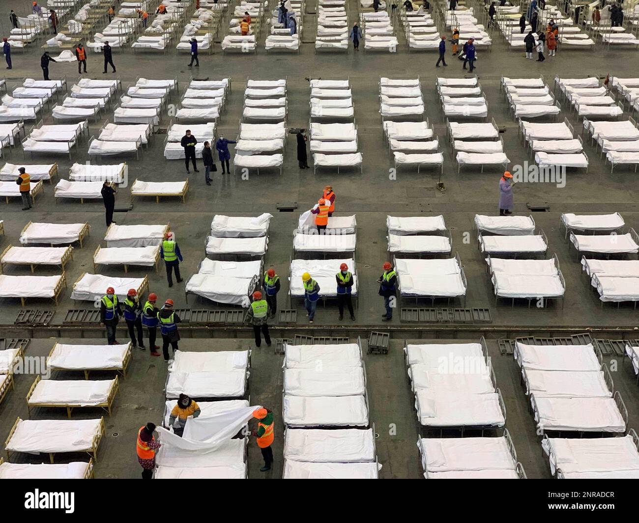 Workers arrange beds in a 2,000-bed mobile hospital set up in an ...