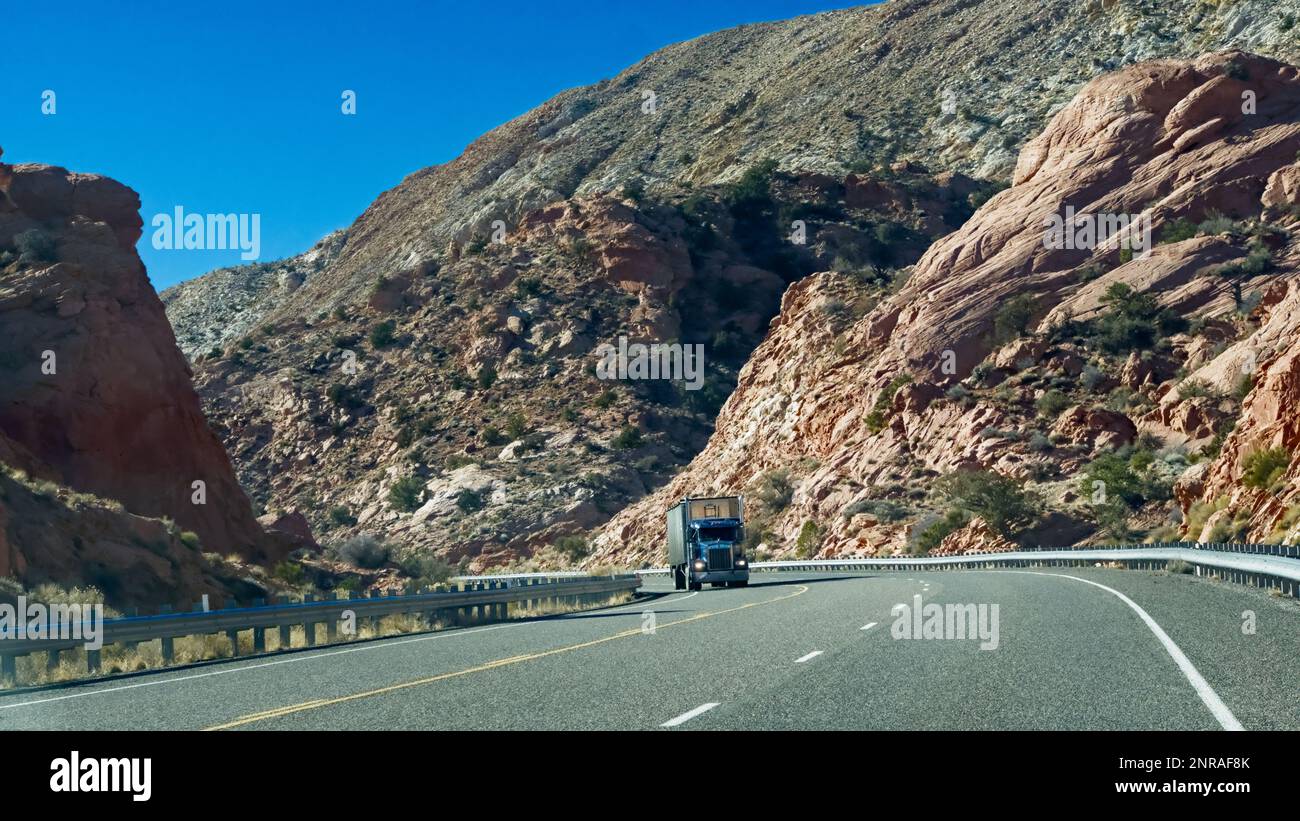 A truck on the curved highway between the two red mountains Stock Photo ...
