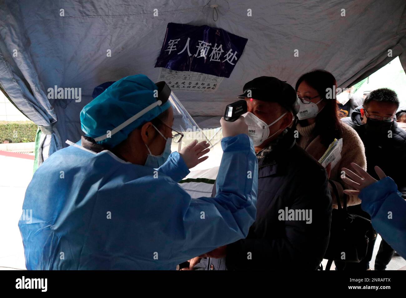 A medical staff screens visitors in the tents outside the clinic ...
