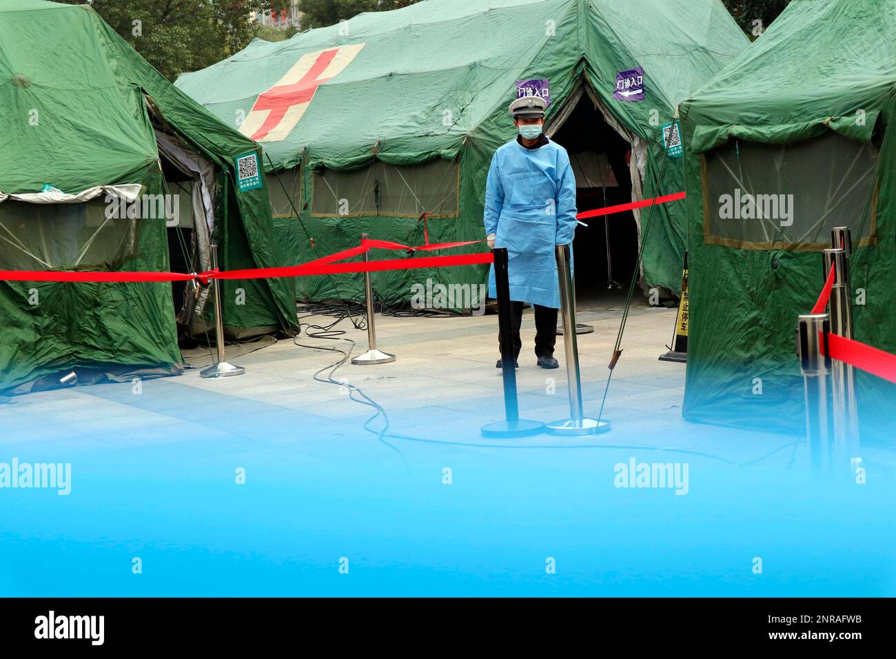 An officer stands between tents for screening visitors outside the ...