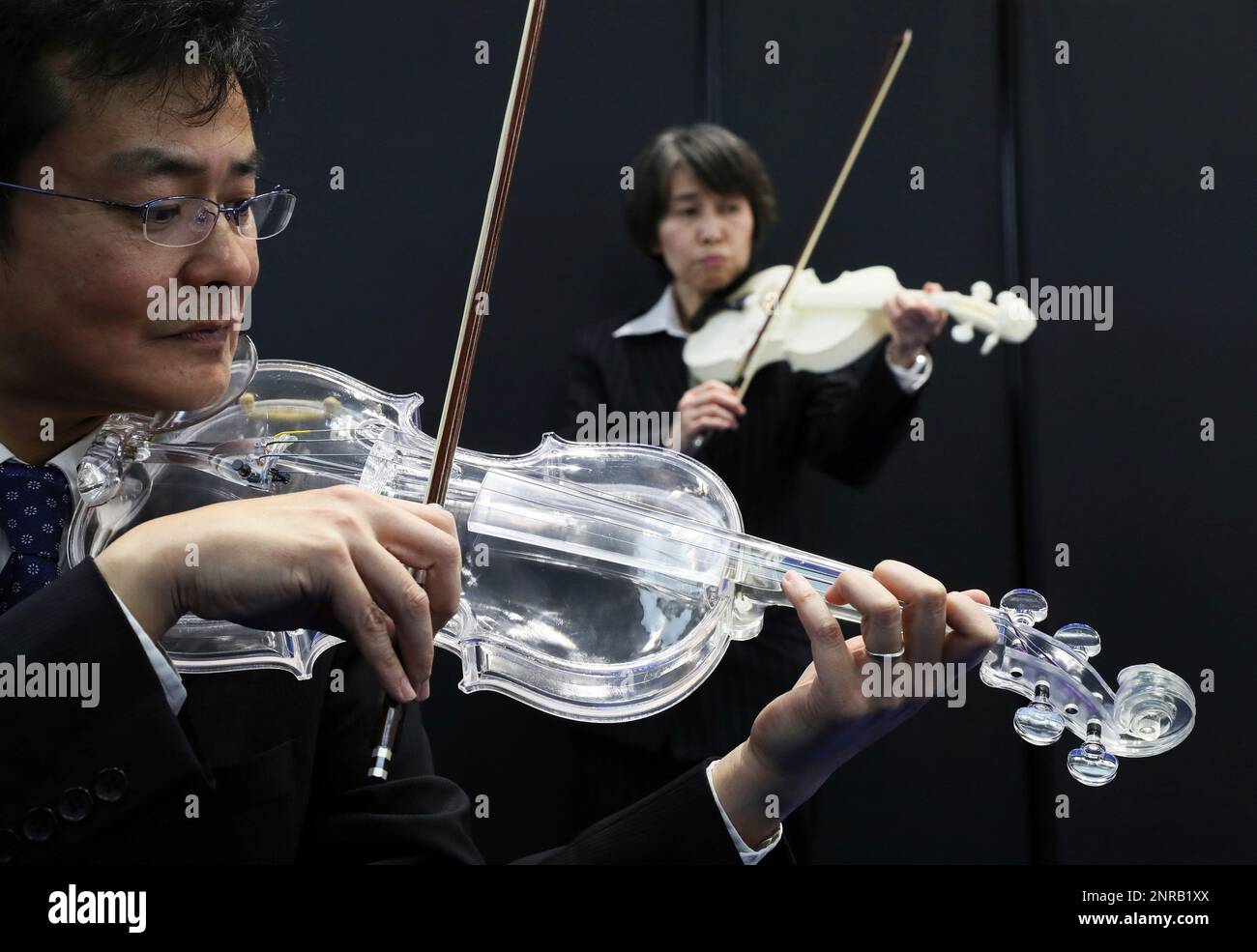 A photo shows a transparent plastic violin made by 3D printer (the back ...