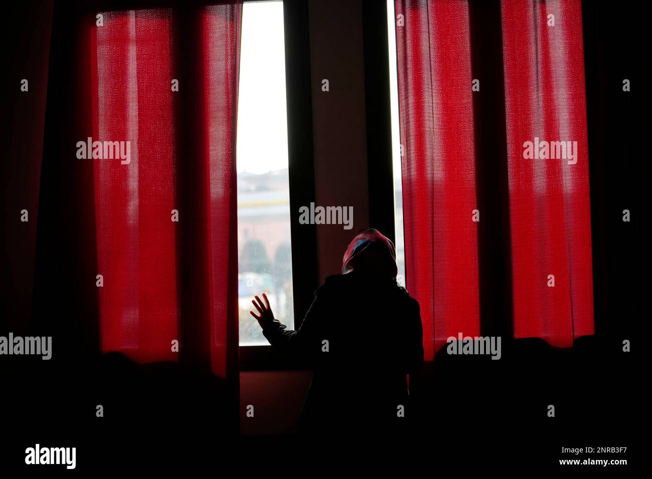 Pakistani-born Iram Aslam, 29, peeks through the window of a local ...