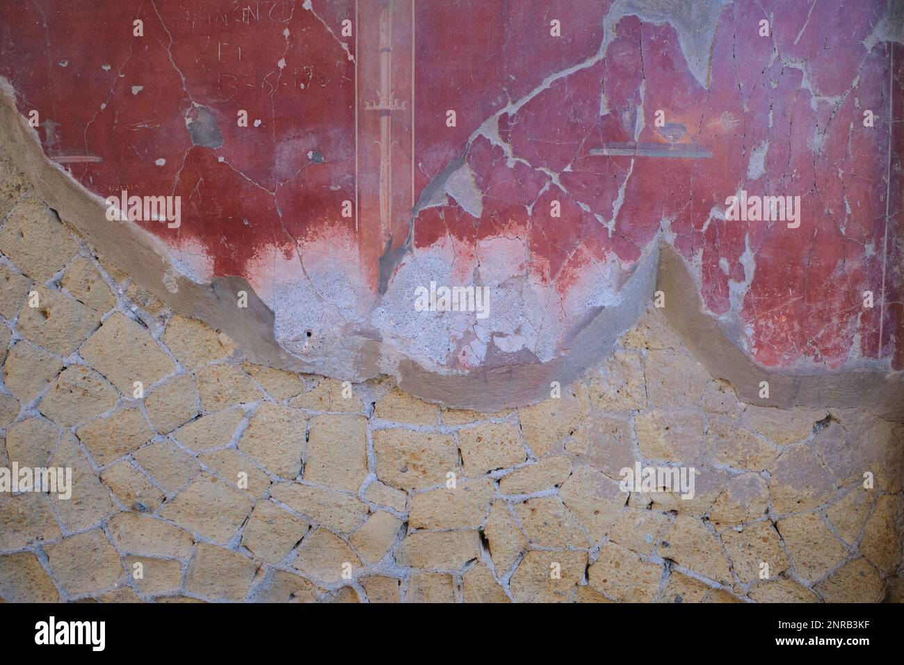 Close up, detail view of a section of red fresco plaster wall work with ...