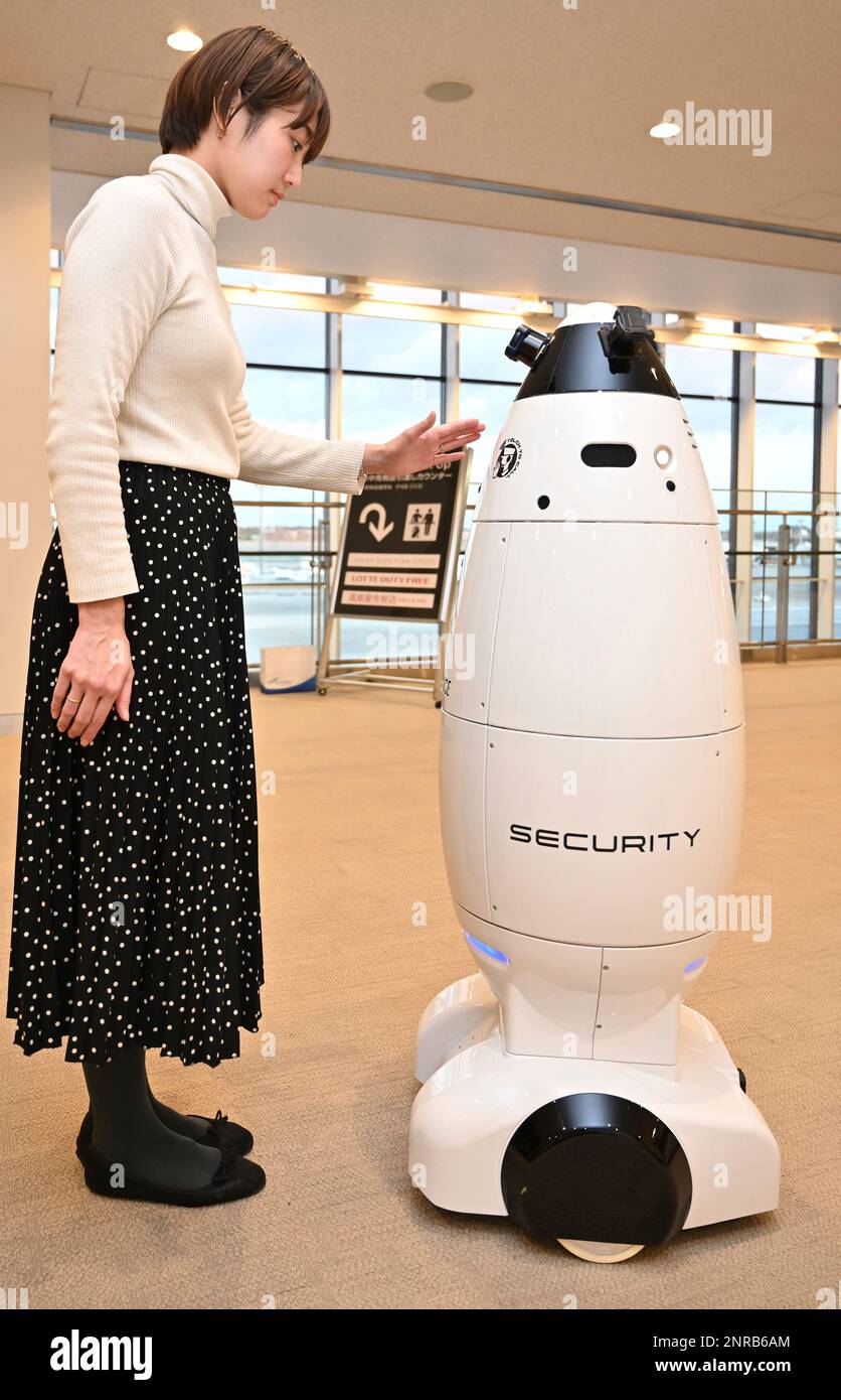 A woman speaks to a sceurity robot operated at the terminal building of ...