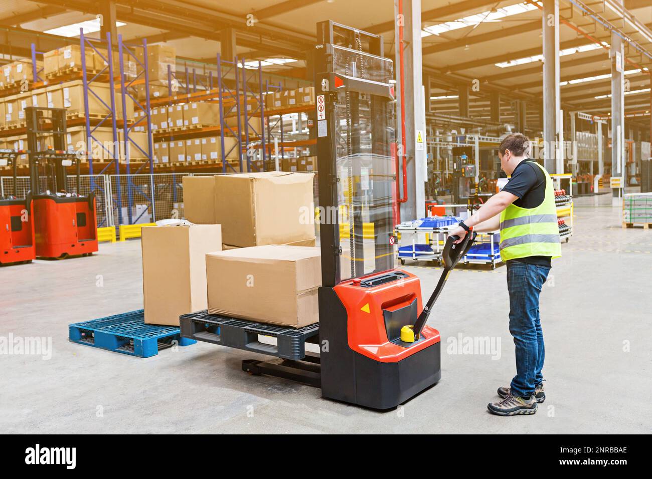 Storehouse employee in uniform working on forklift in modern automatic ...