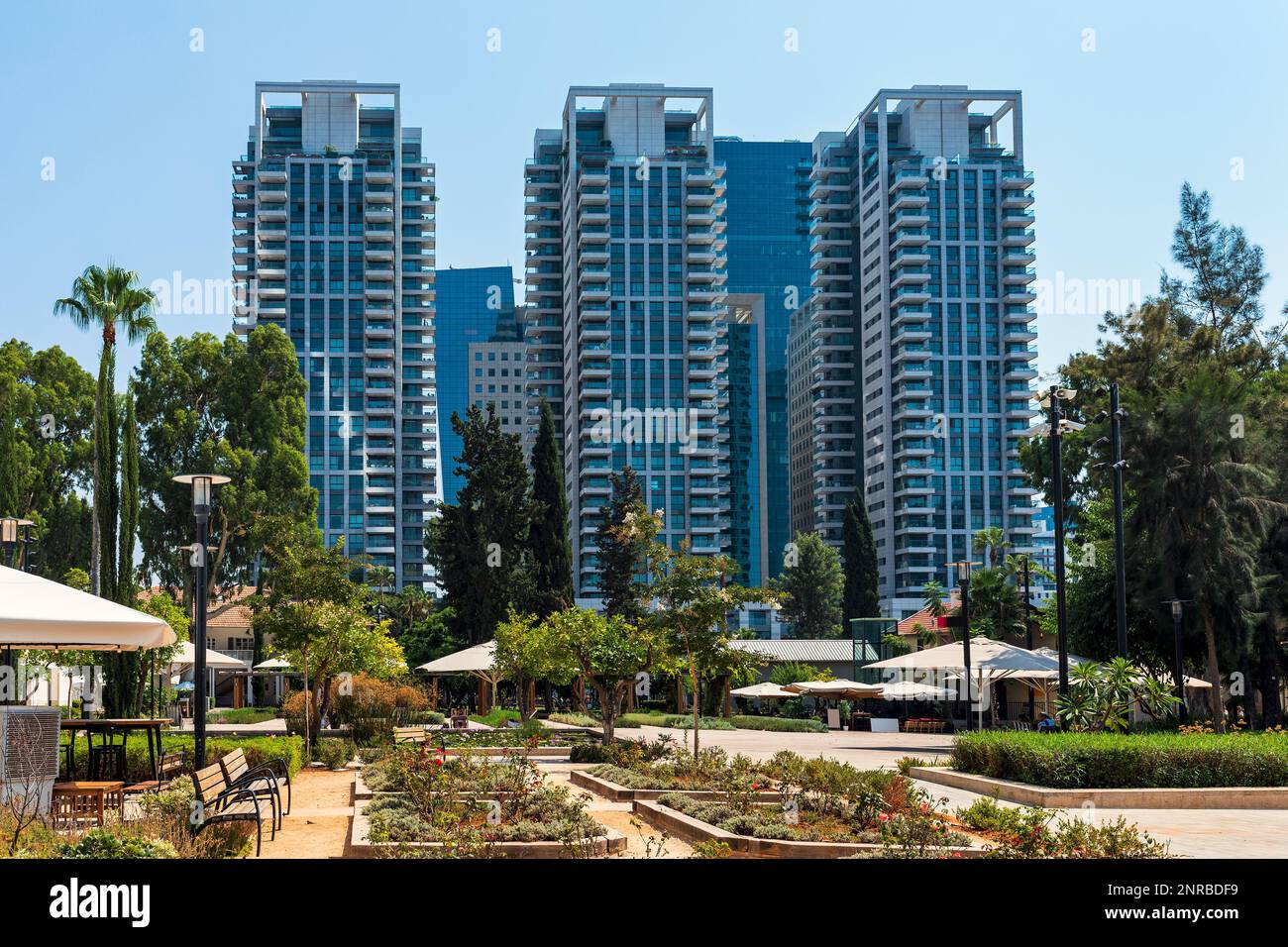 Urban park at Sarona market and modern residential high-rise buildings ...