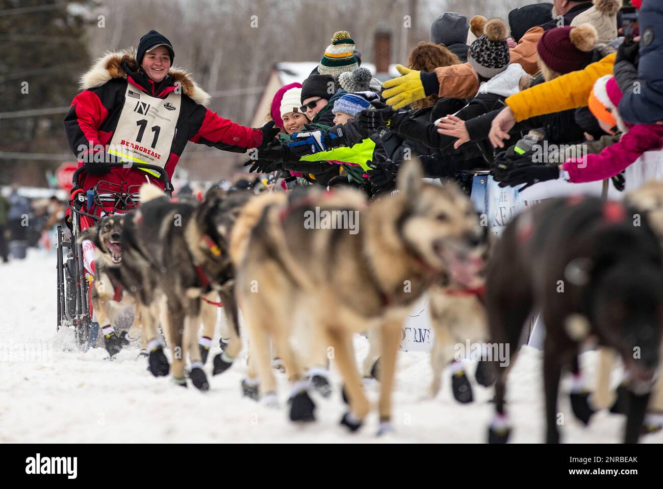 Laura Neese high-fives spectators near the starting line as she takes ...