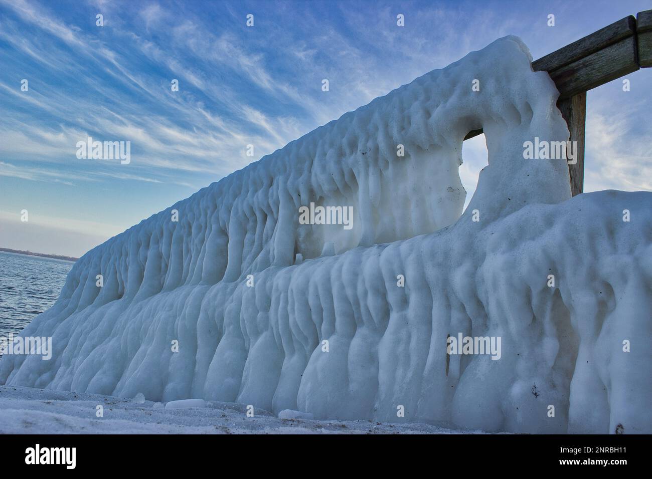 View of a frozen jetty in Travemünde in Germany with thick icicles on ...