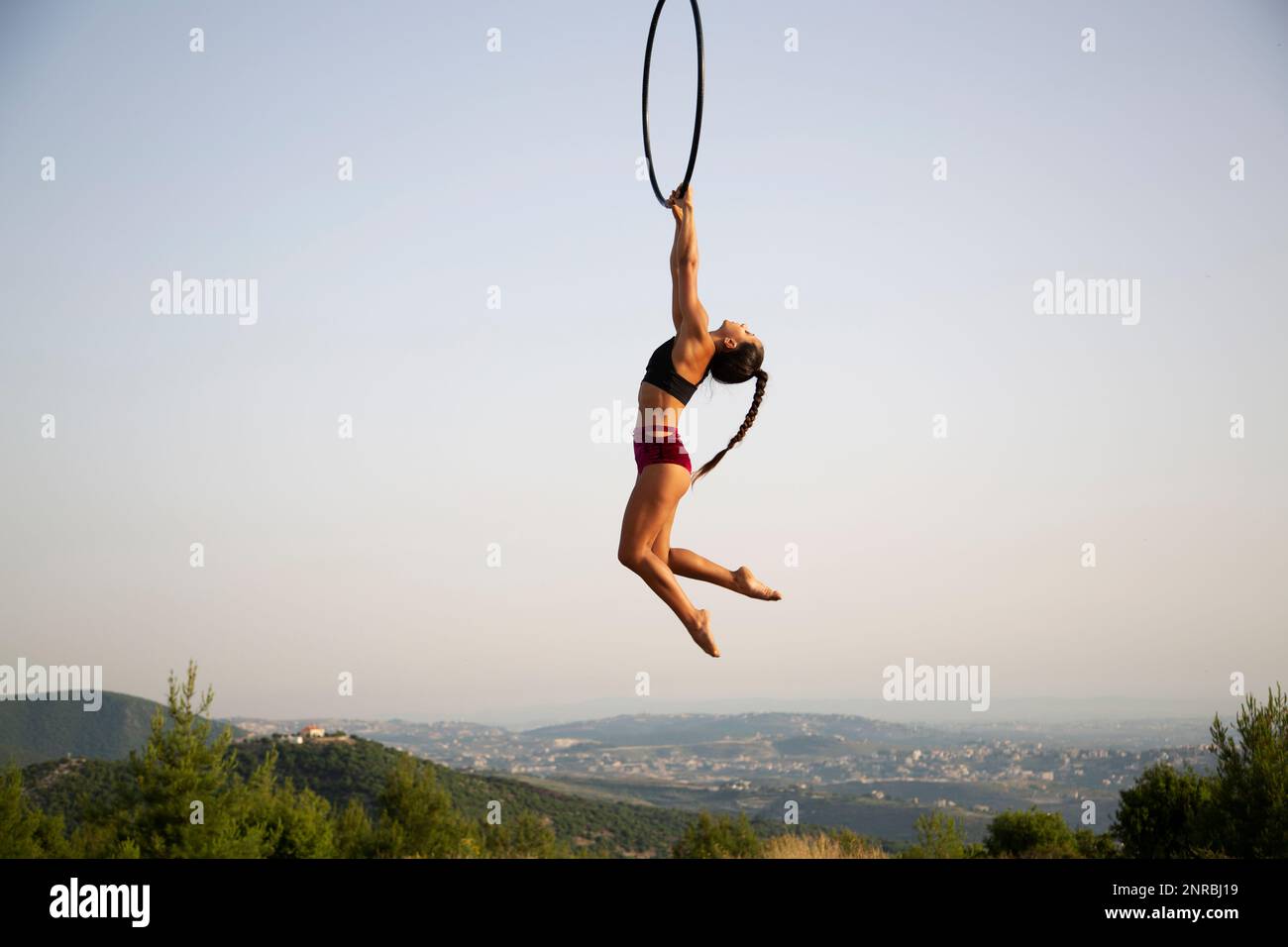 Young female aerialist performing on the hoop outdoors Stock Photo - Alamy