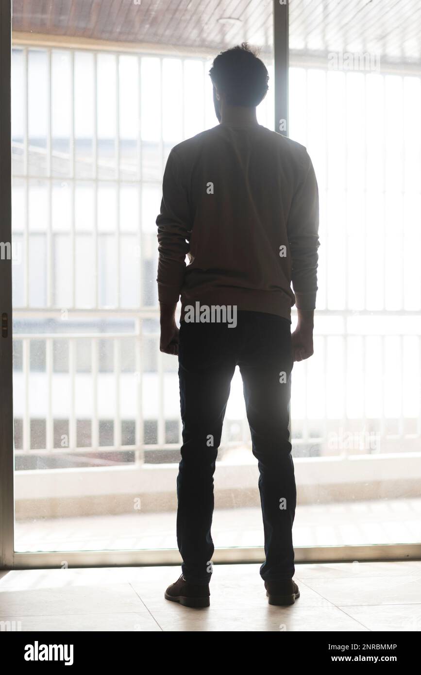 Rear view of man standing indoors Stock Photo - Alamy