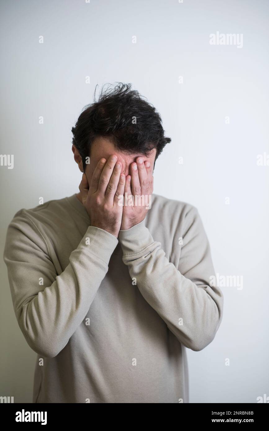 Man hiding face in hands crying Stock Photo - Alamy