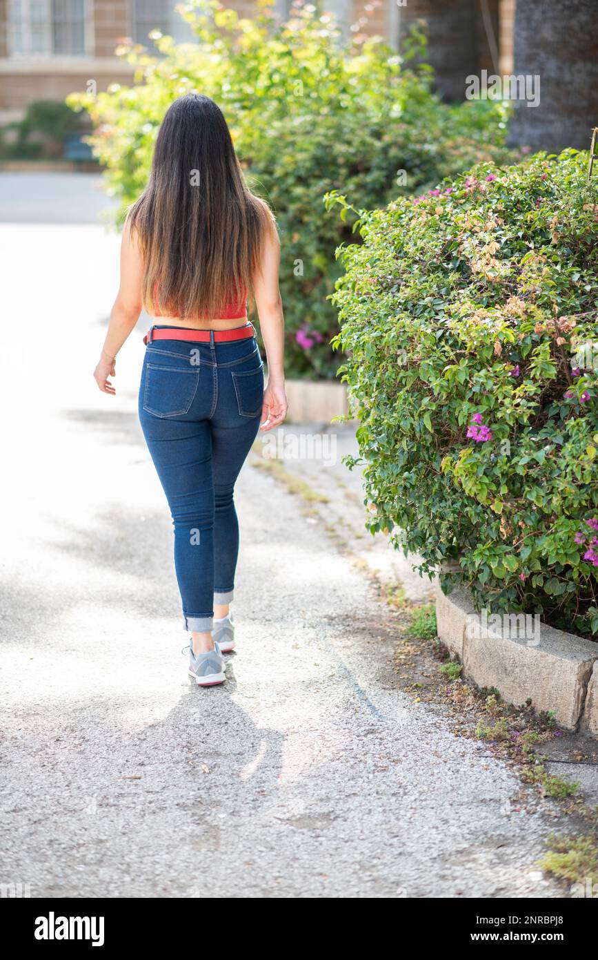 Young woman walking away Stock Photo - Alamy