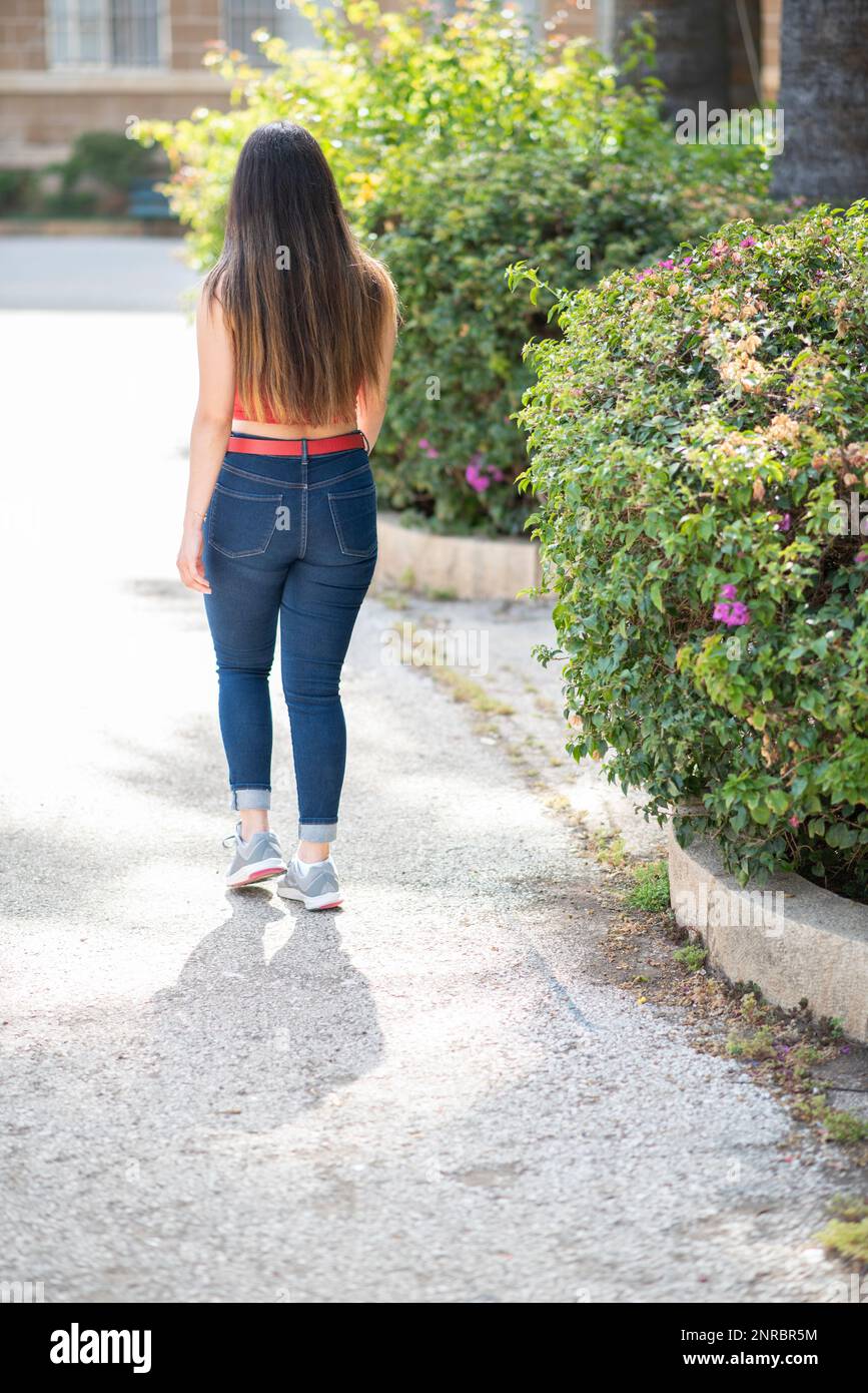 Woman walking away on the street Stock Photo - Alamy