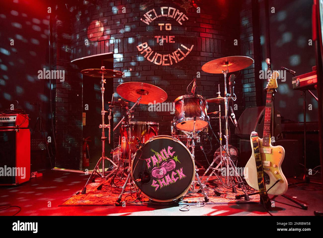 The stage is prepared with a drum kit and microphones for a live ...