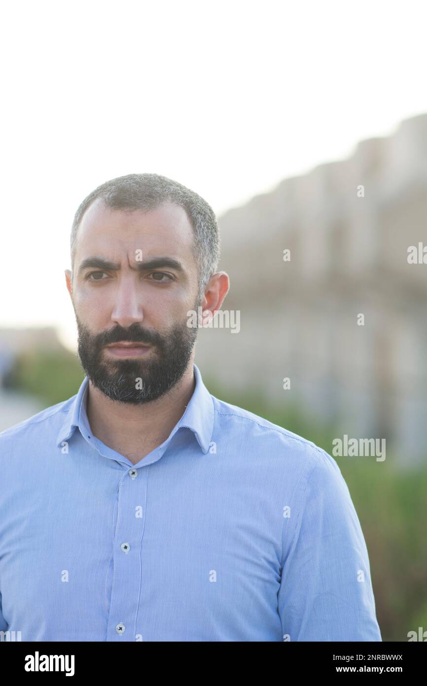 Serious Middle Eastern man looking away outdoors Stock Photo - Alamy